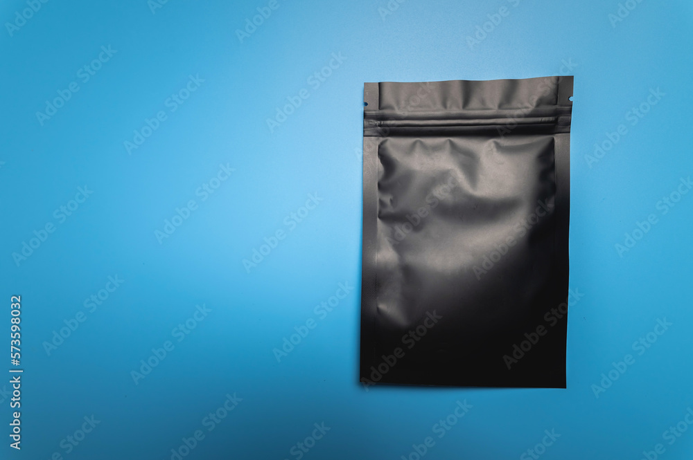 Mockup of a black packaging for coffee beans, lying on the table ...