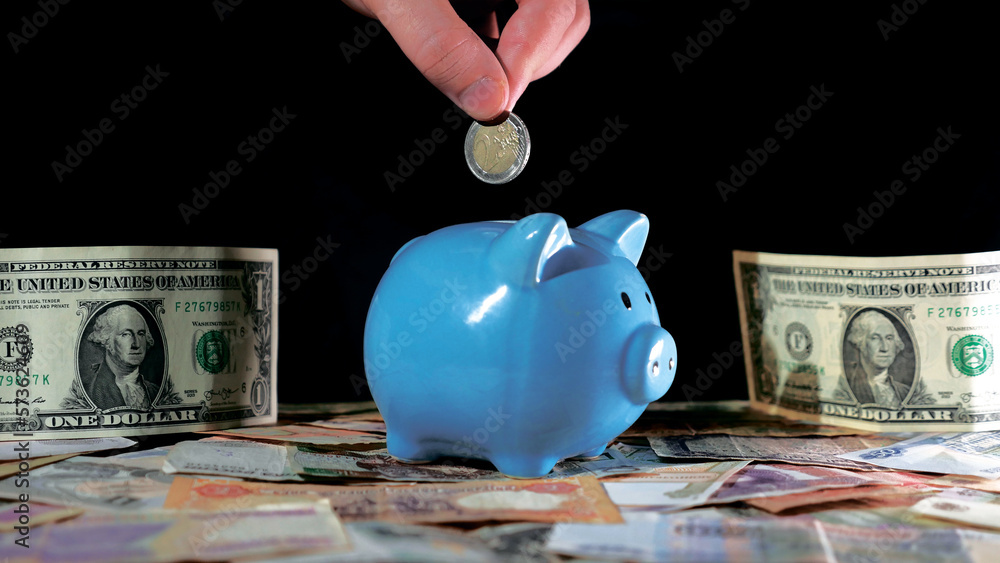 Piggy bank and money. the man is going to throw 2 euros into the piggy ...