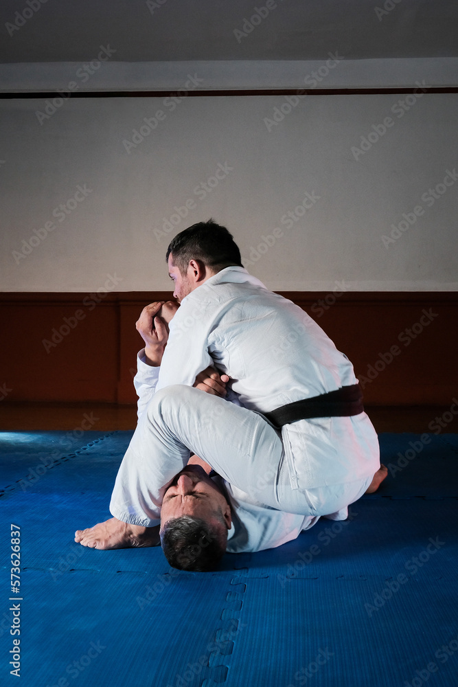 Two latin men training martial arts with kimonos and one black belt and ...