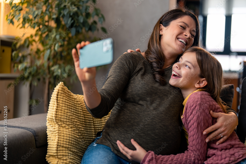 Cheerful little child making mom laughing while hugging and tickling ...
