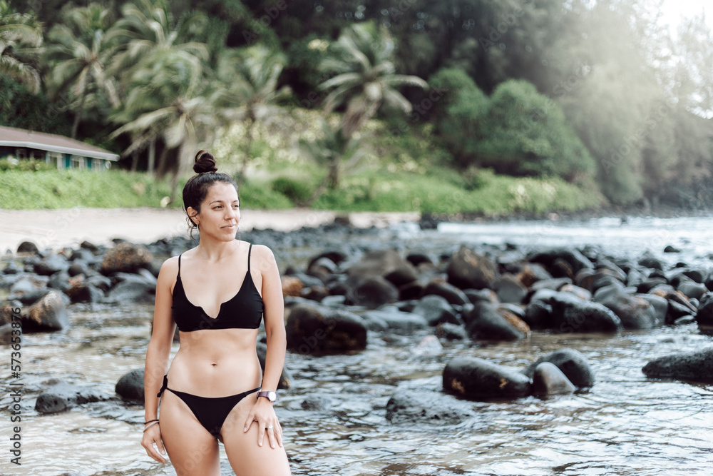 Foto de Sexy young woman in bikini standing on tropical beach. Paradise do Stock | Adobe Stock