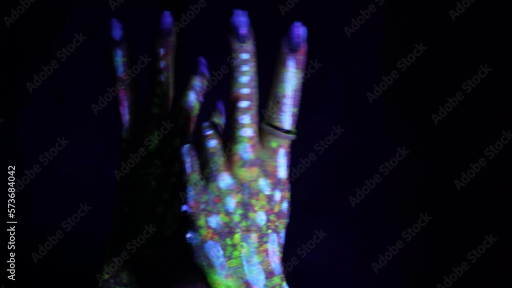 A hand with a fluorescent ethnic pattern shows two fingers. Fluorescent ...