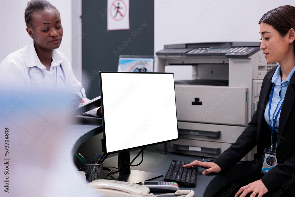 Asian reception worker using white screen on computer while working at ...