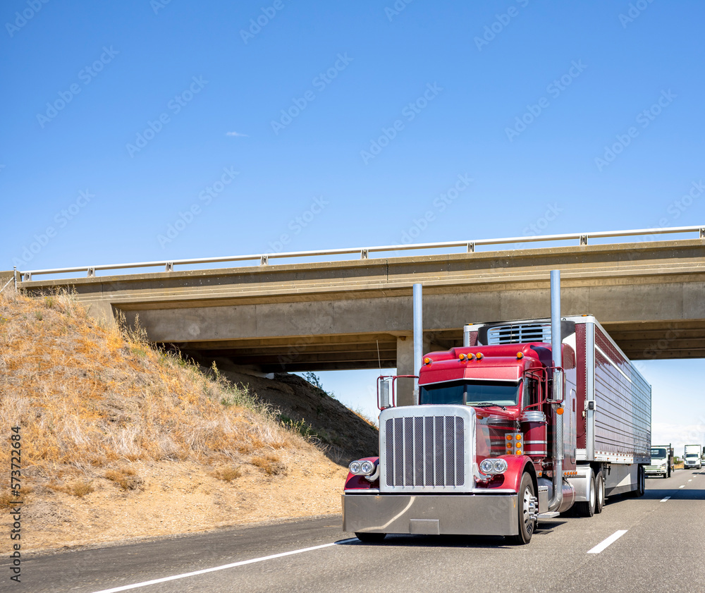 Classic American burgundy big rig semi truck with chrome accessories ...