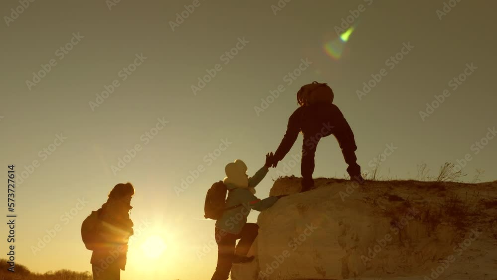 Travelers climb cliff one by one. Teamwork concept. Silhouettes of ...