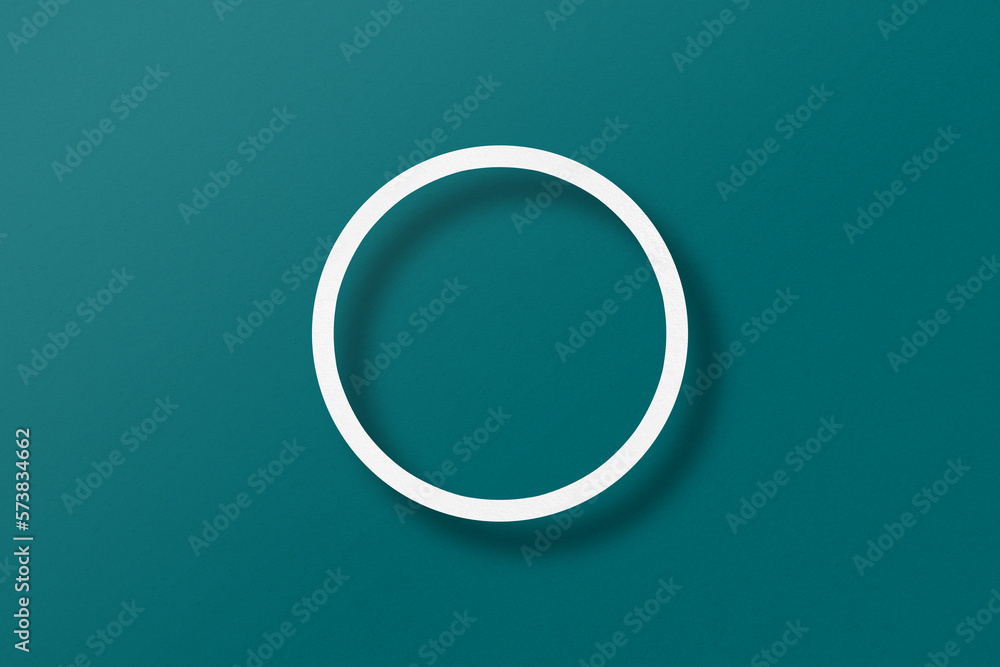 paper cut into circle shape with light and shadow placed on a green ...