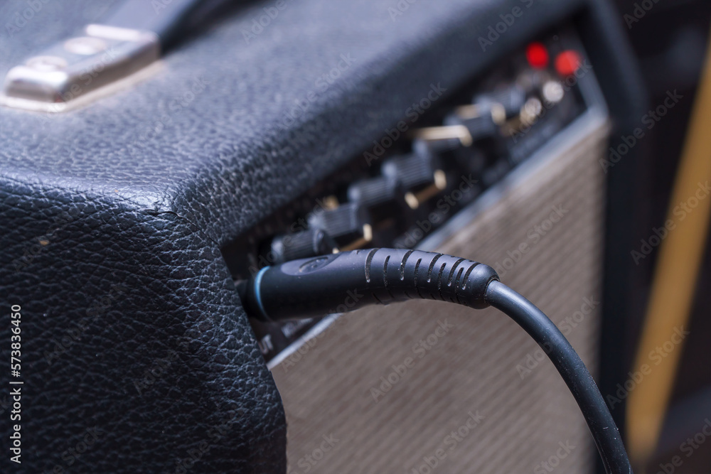 Plug jack with cable plugged into a black guitar combo amplifier Stock ...