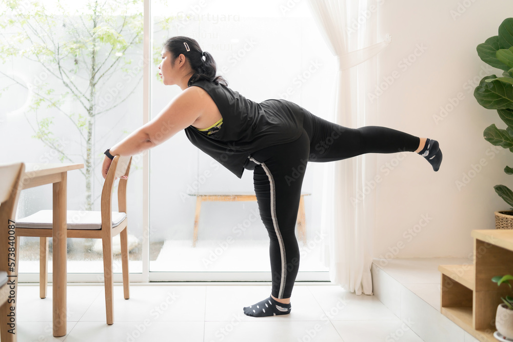 fat woman doing chairs exercise indoors living room balance plank ...