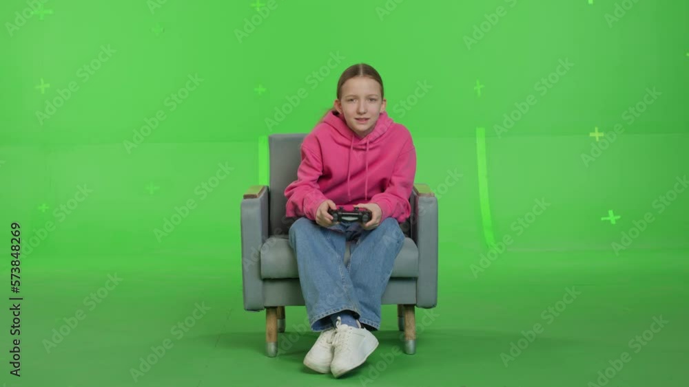 Young caucasian girl sitting on a chair, Playing in Video Games on a ...