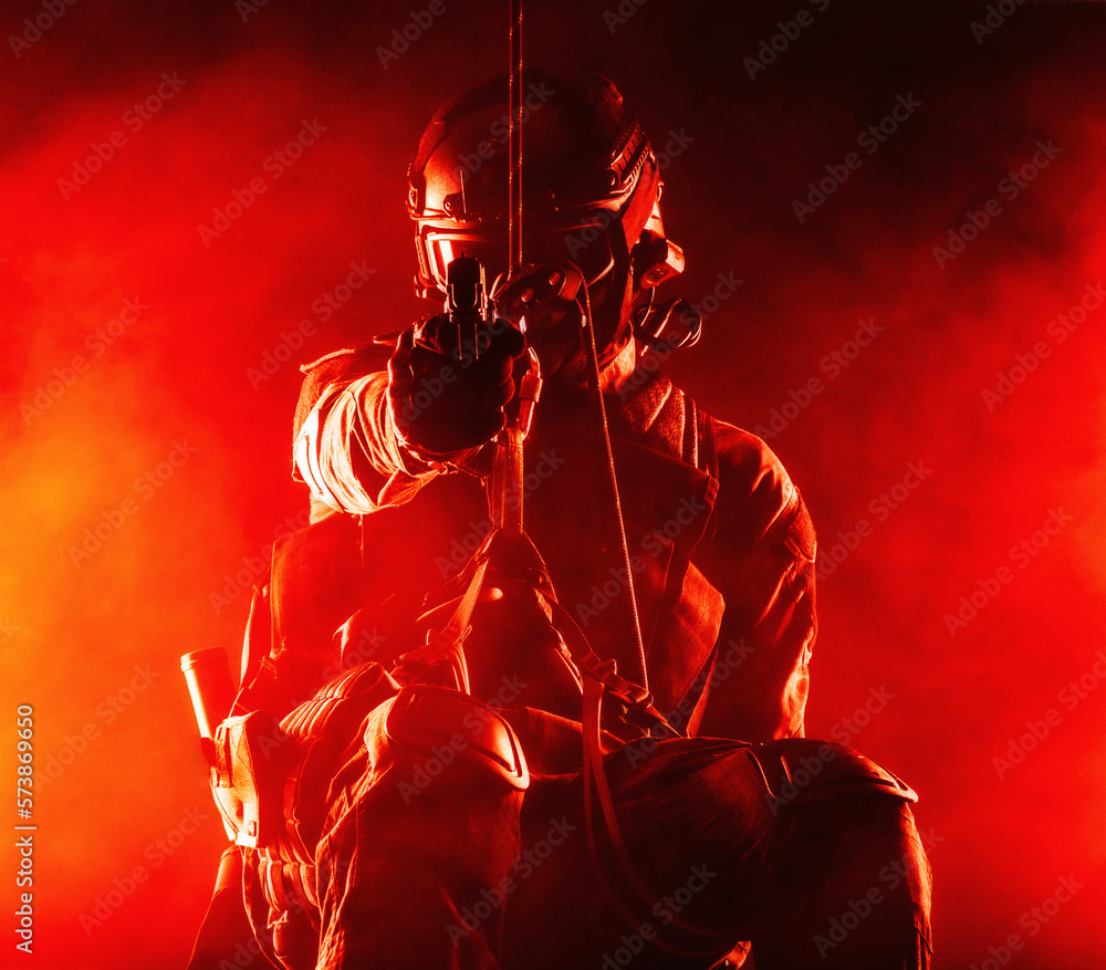 Silhouette of police officer in tactical gear descending from a height ...