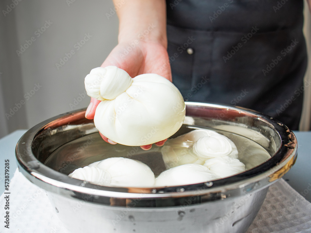 cheese maker making mozzarella or buratta, hands holding buratta cheese ...