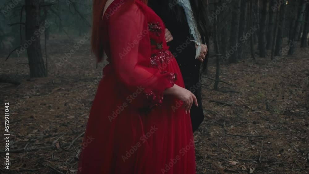 Goth man vampire in black tailcoat walking with gothic woman holding ...