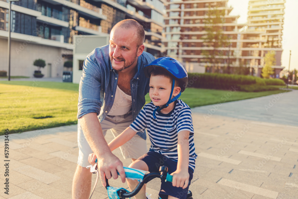 Father teaching his child to drive a bicycle. Portrait of father and ...