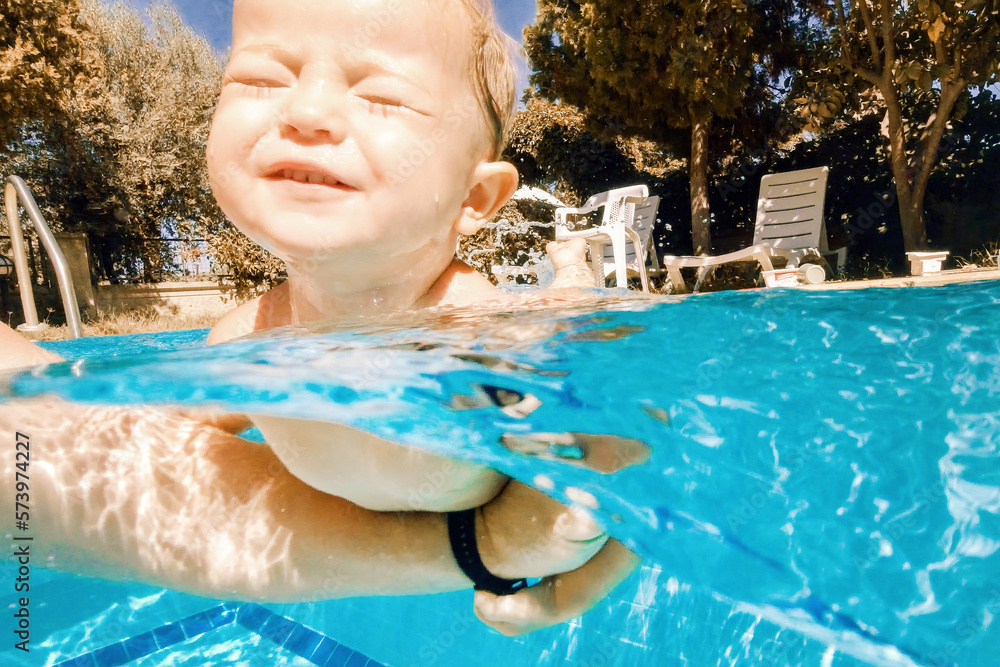 Fun with water. Cute baby swims underwater. Little girl is playing in ...
