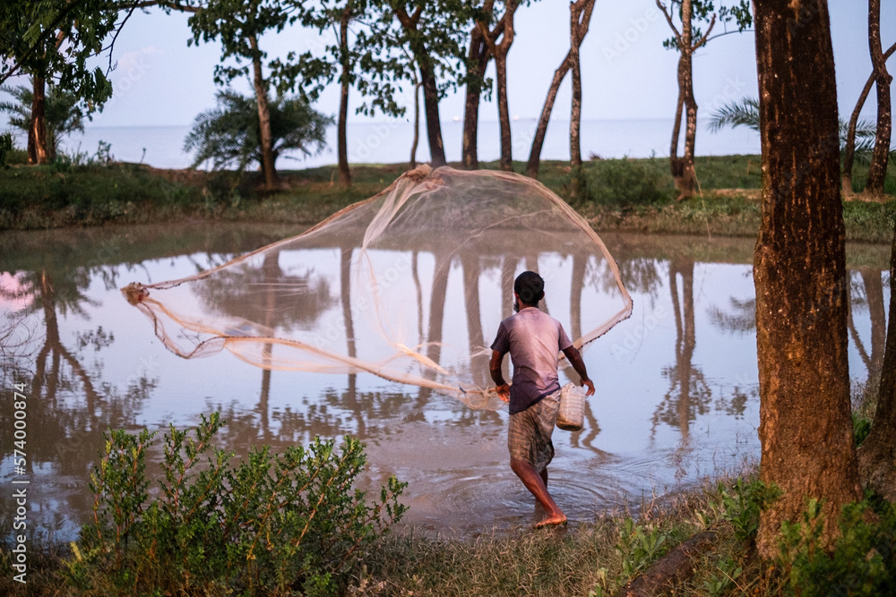 Rural fisherman throwing fishing net in a pond near a river Stock Photo ...