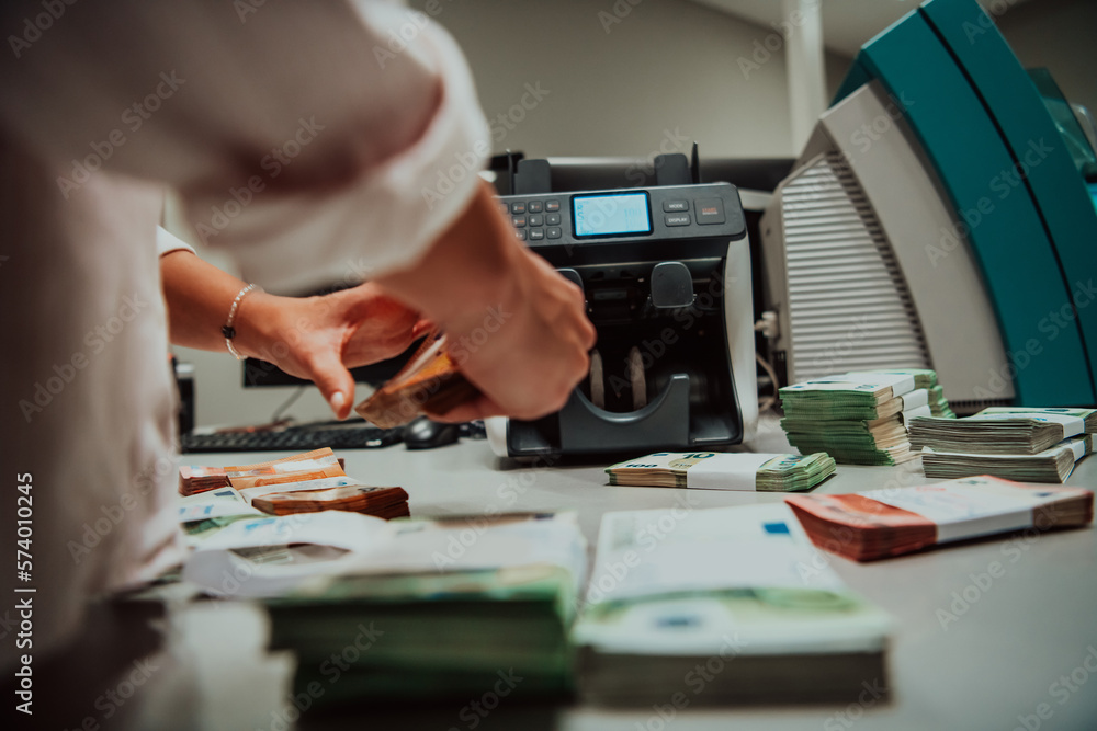 Bank employees using money counting machine while sorting and counting ...
