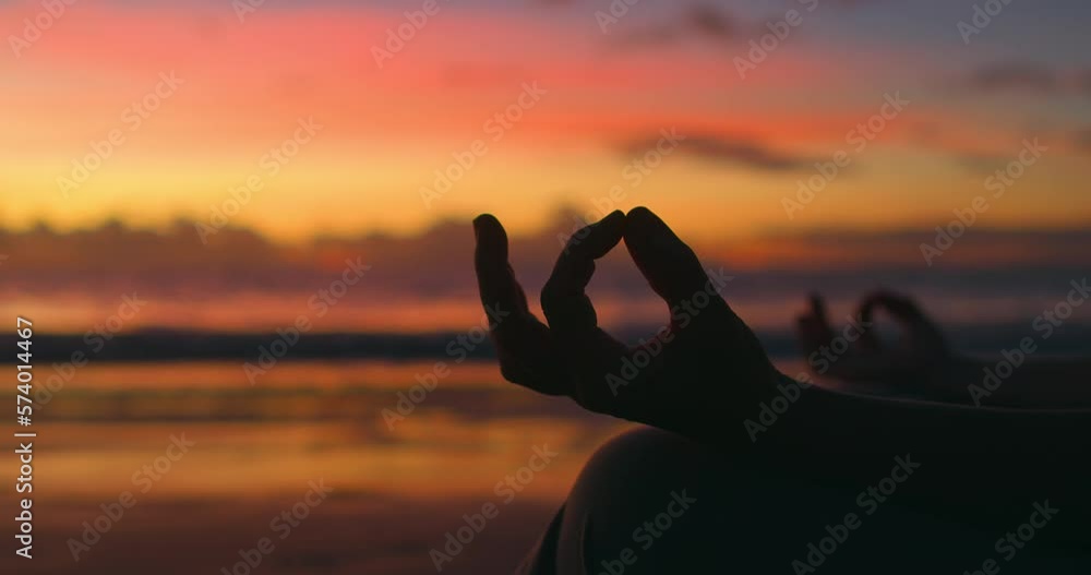 Woman does yoga at dawn on ocean. Silhouette of woman's hands ...