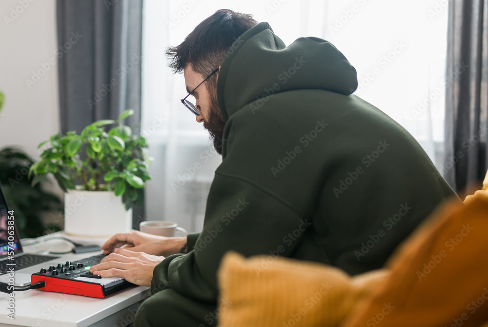 Man recording electronic music track with portable midi keyboard on ...