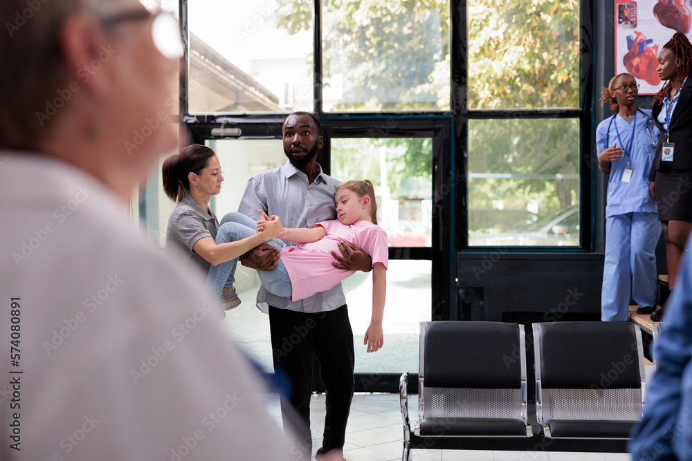 Worried african american dad holding unconscious little daughter in ...