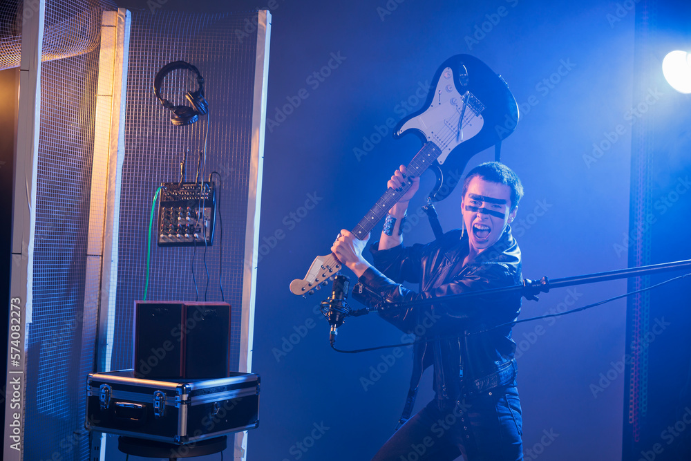 Cool stylish musician holding bass guitar to smash and act crazy ...