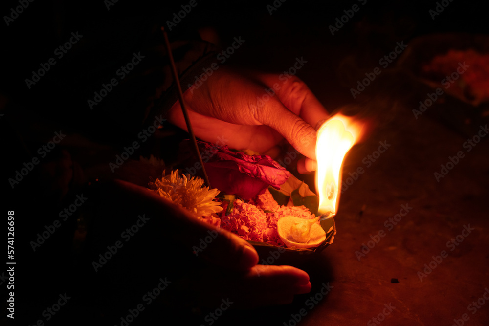 Hand of a person, female, woman, man lighting a lamp during diwali at a ...