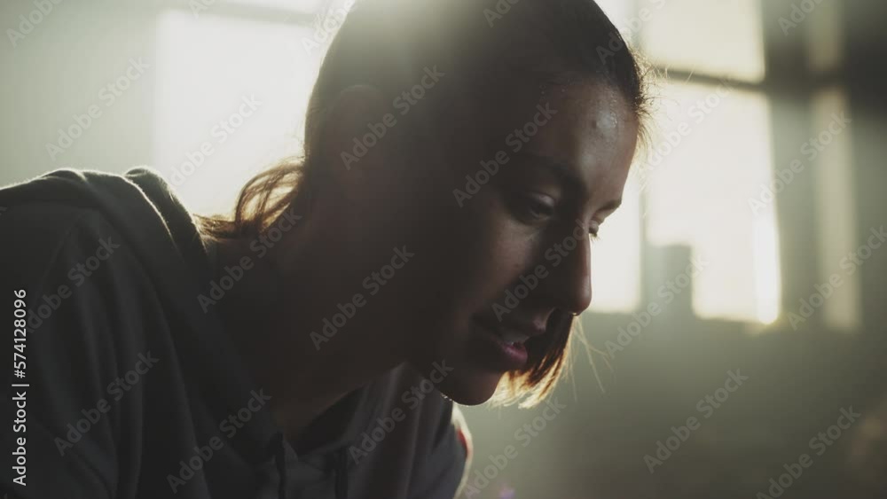 Close-up portrait of a beautiful sweaty woman tired after gym, resting ...
