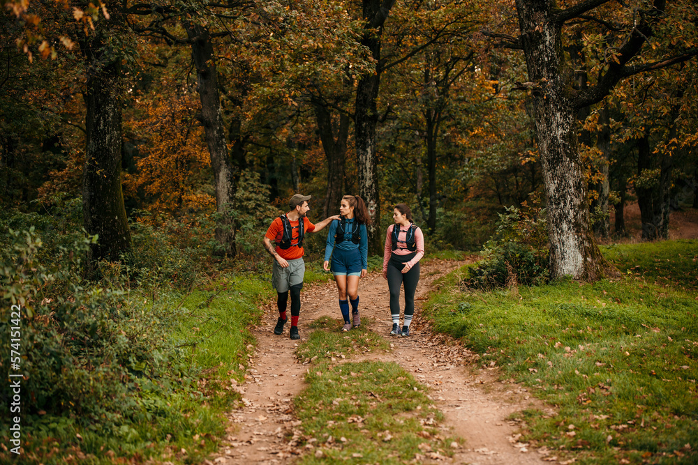 Young male and female joggers walk after a long run in the forest ...
