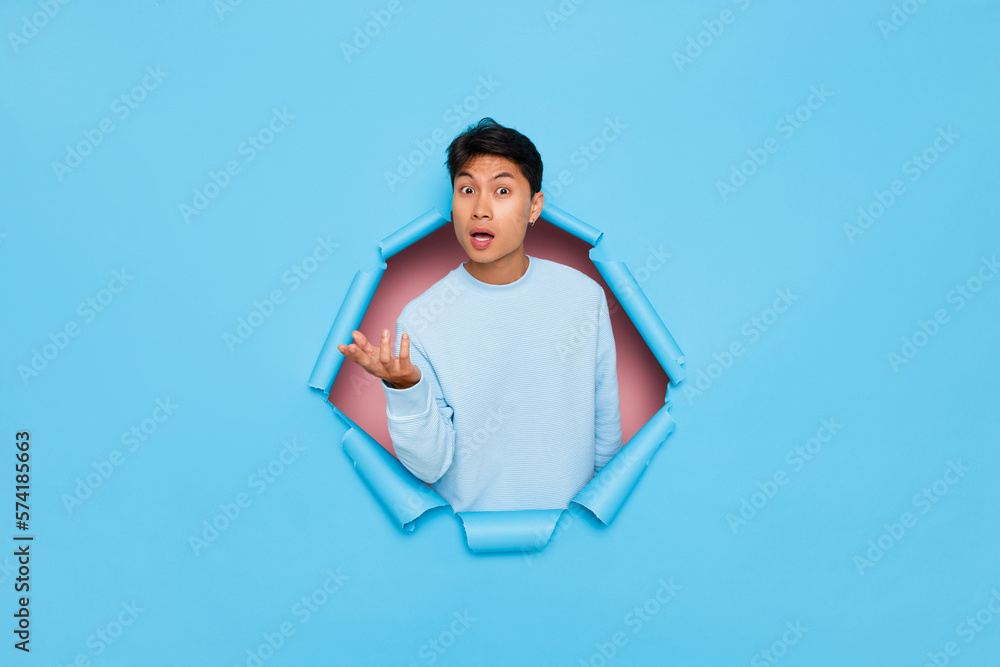 Surprised Asian young man holds palm aside with questionable face ...