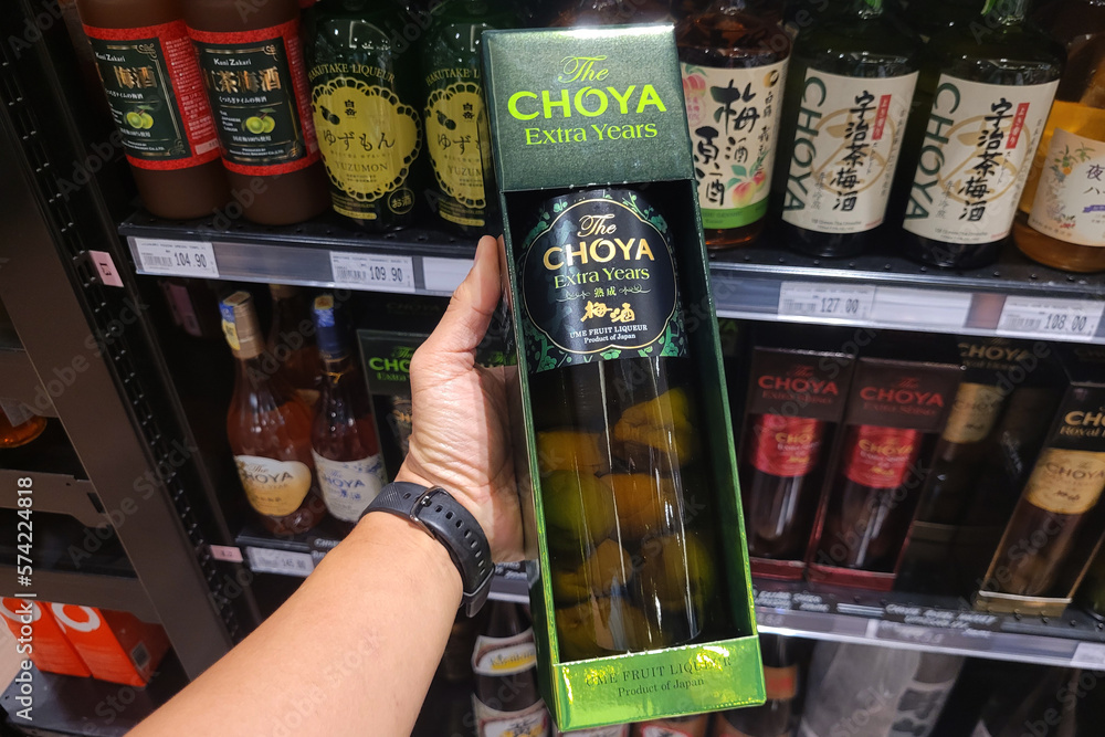 PENANG, MALAYSIA - 22 FEB 2023: Adult hands holding a bottle of Choya ...