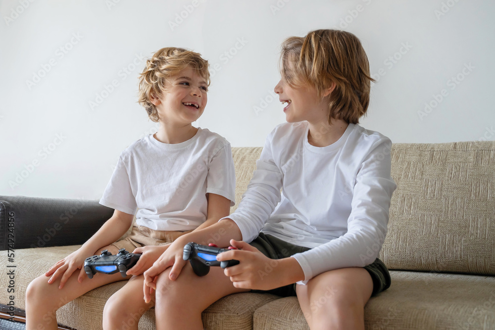 Cute children joyful playing video games with controller console ...