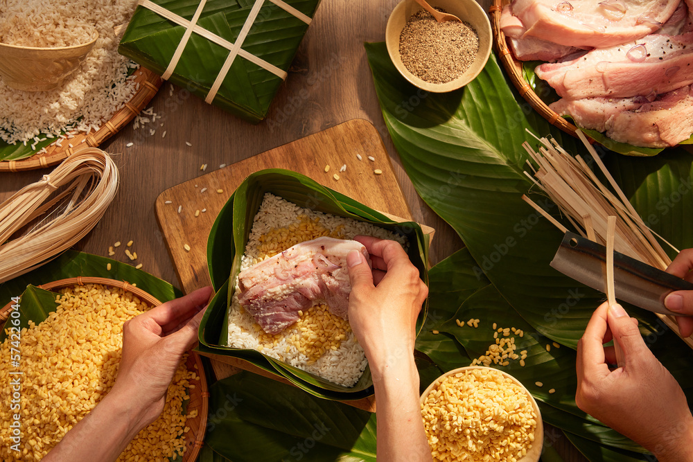 Top view of chef making Chung cake with pork rice and corn in wooden ...