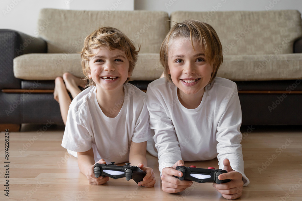 Cute children joyful playing video games with controller console ...