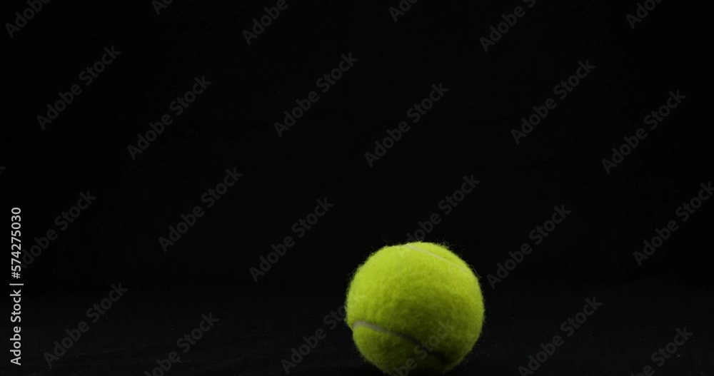 Green tennis ball bouncing isolated on black background. The tennis ...