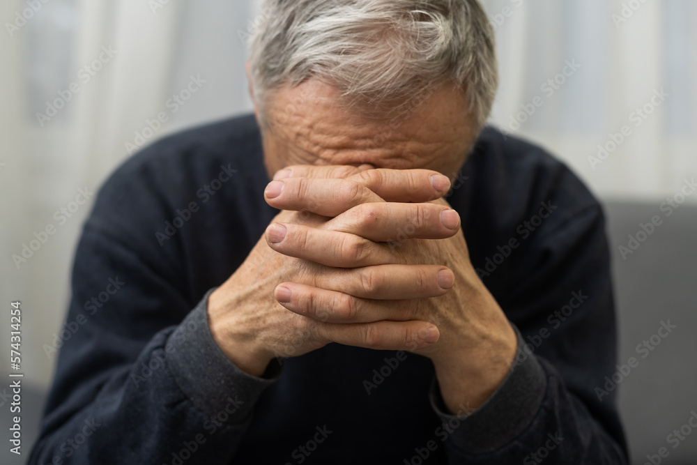 Please, Lord. Nervous worried aged Caucasian man praying on couch at ...