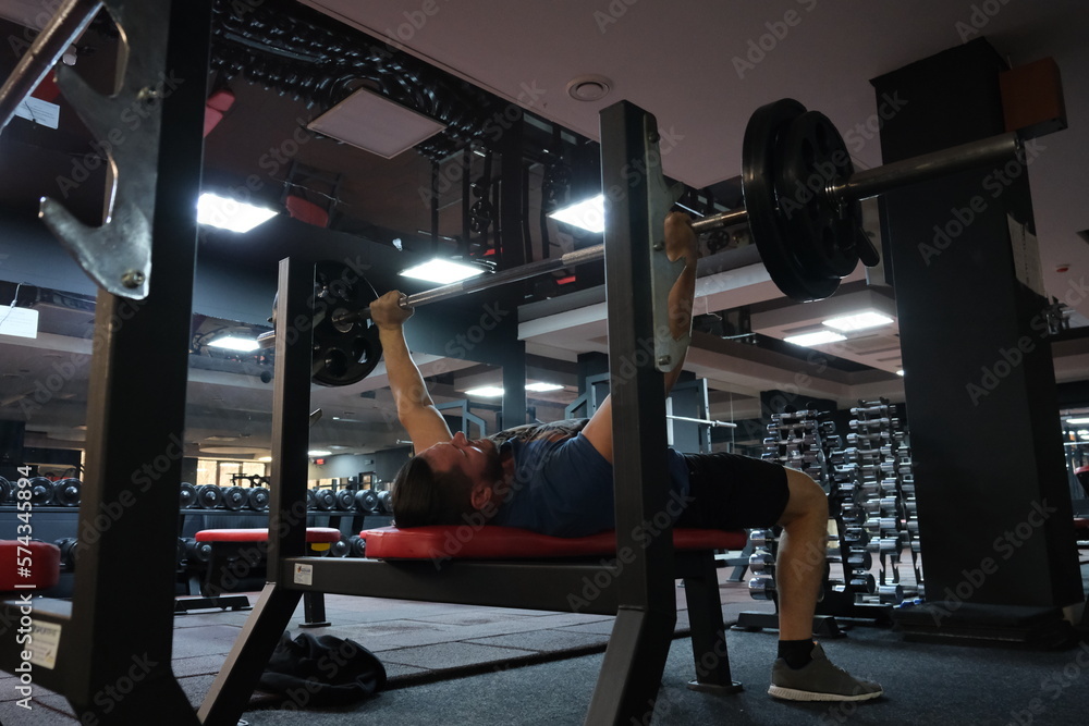 February 21, 2023 Ukraine, Dnipro. Barbell bench press. A young athlete ...