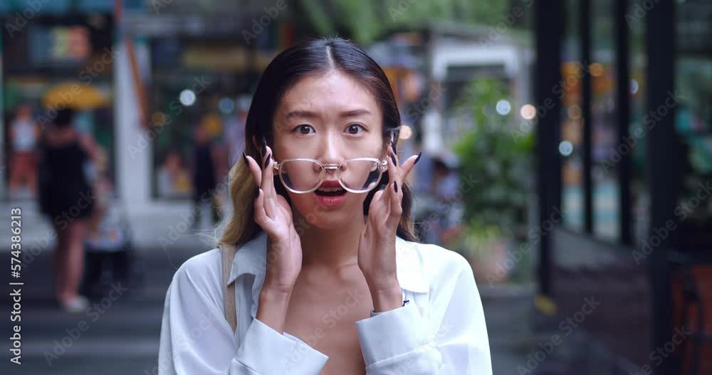 Amazed asian female shocked, look at camera takes off glasses. Portrait ...