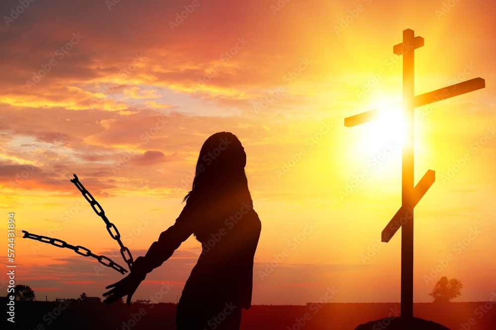 Silhouette of woman break chains with Holy Cross on background Stock ...