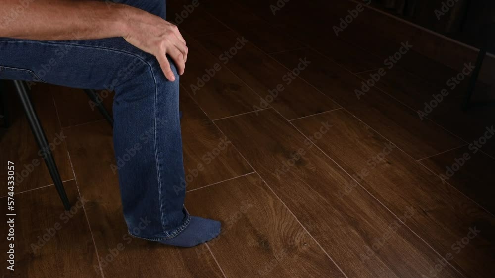 male white hand on knee while leg repeatedly uncontrollably shakes up ...