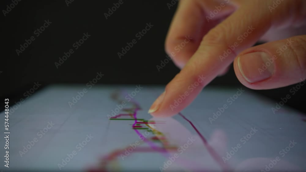 Closeup finger touching screen with diagram and put dollar bills on it ...