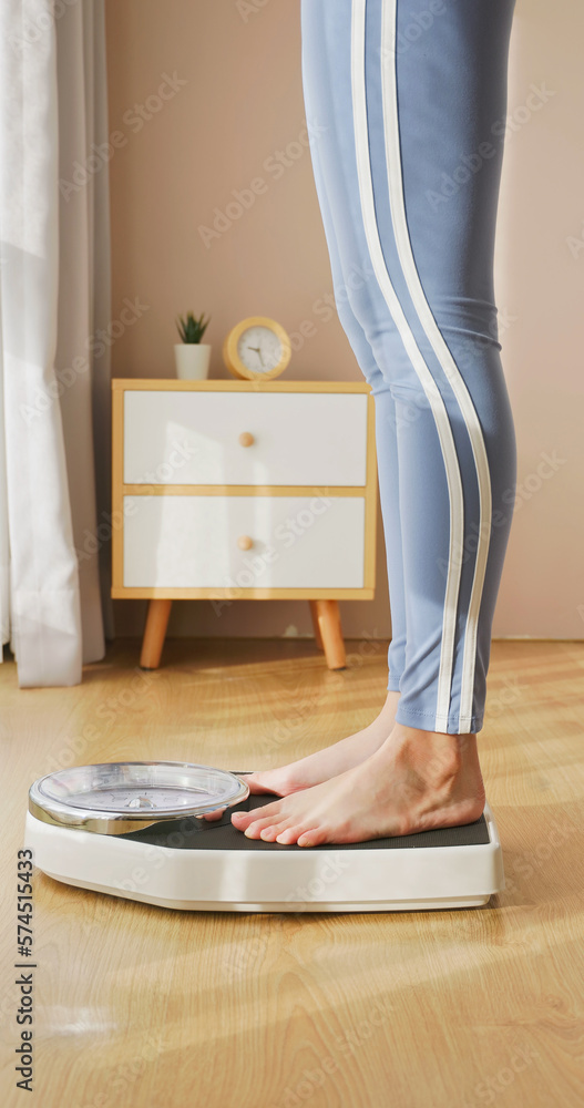 woman measure weight on scale Stock Photo | Adobe Stock