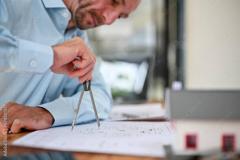 Professional Caucasian male engineer using a divider compass, drawing ...