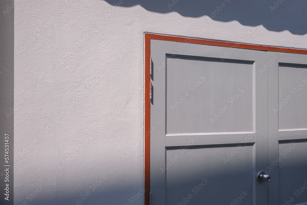 Sunlight and shadow on surface of wooden door on gray cement wall of ...