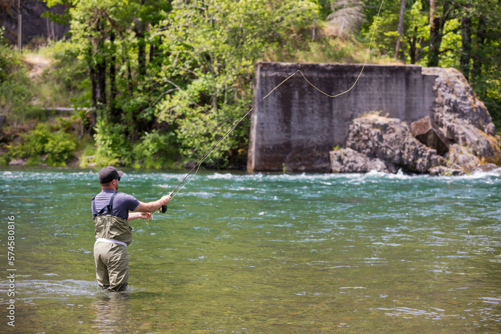 Fly fisherman casting to rising fish in the Summer along the McKenzie ...