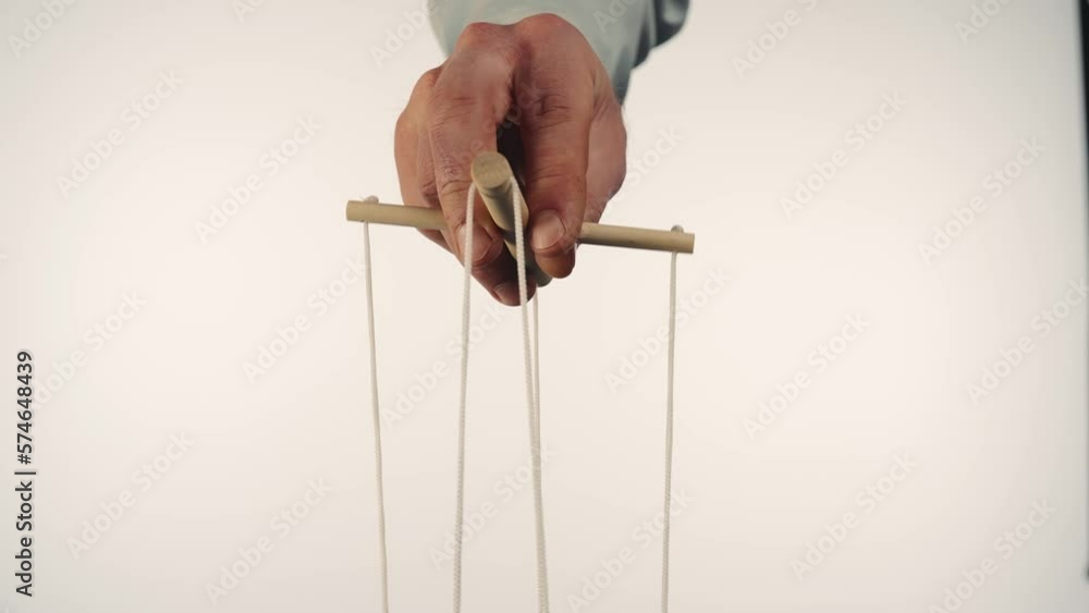 The puppeteer's hand controls the puppet with a wooden manipulator and ...