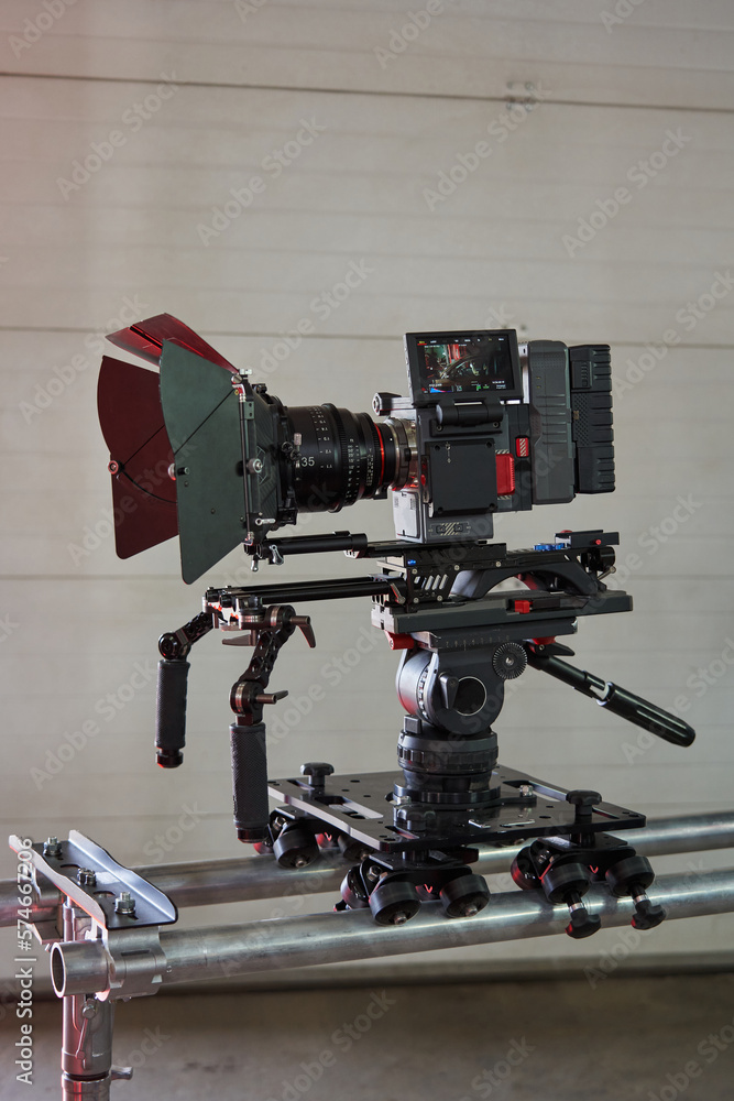 side view of a professional movie camera that stands on a camera ...