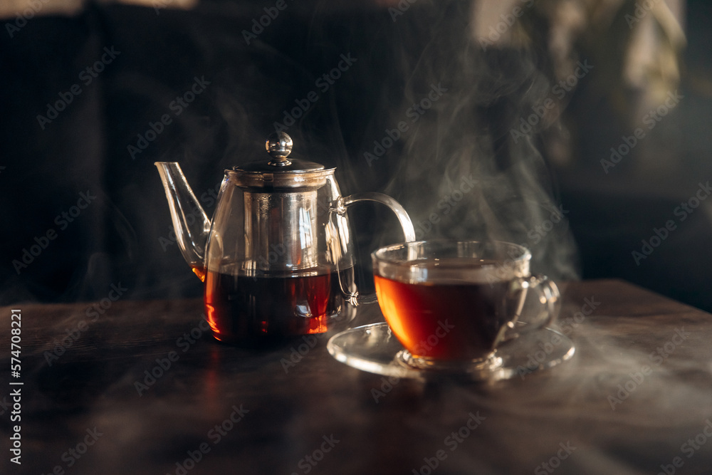 Close-up photo of a transparent teapot filled with tea and a ...