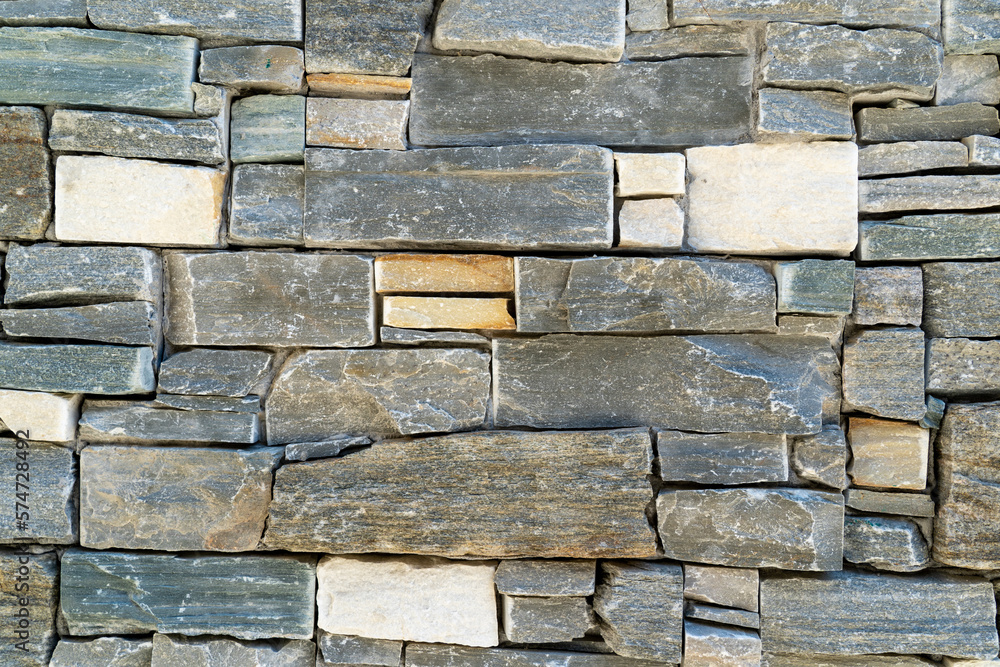A wall made by stacking small stone slabs on top of each other ...