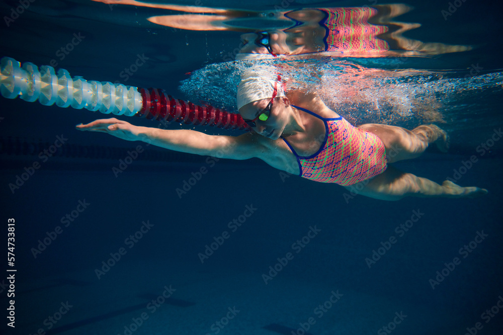 Coordination of movements. Professional female swimmer in cap and ...