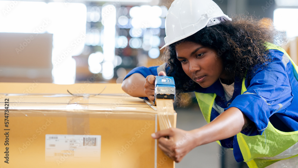 Young beautiful female worker wearing Safety helmet using tape ...