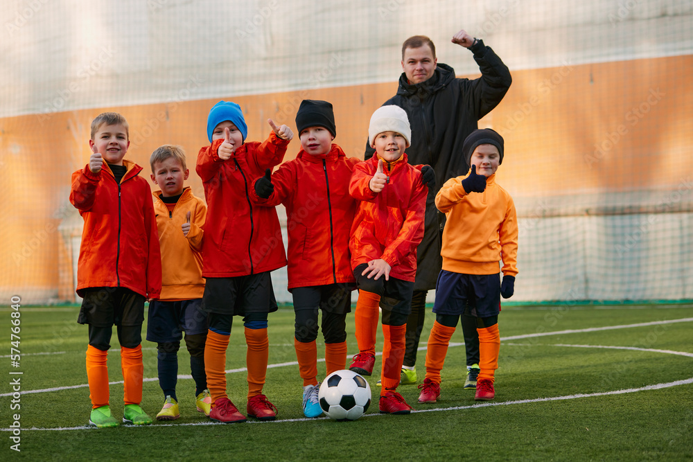 Group of boys, children, football players in uniform standing in a line ...